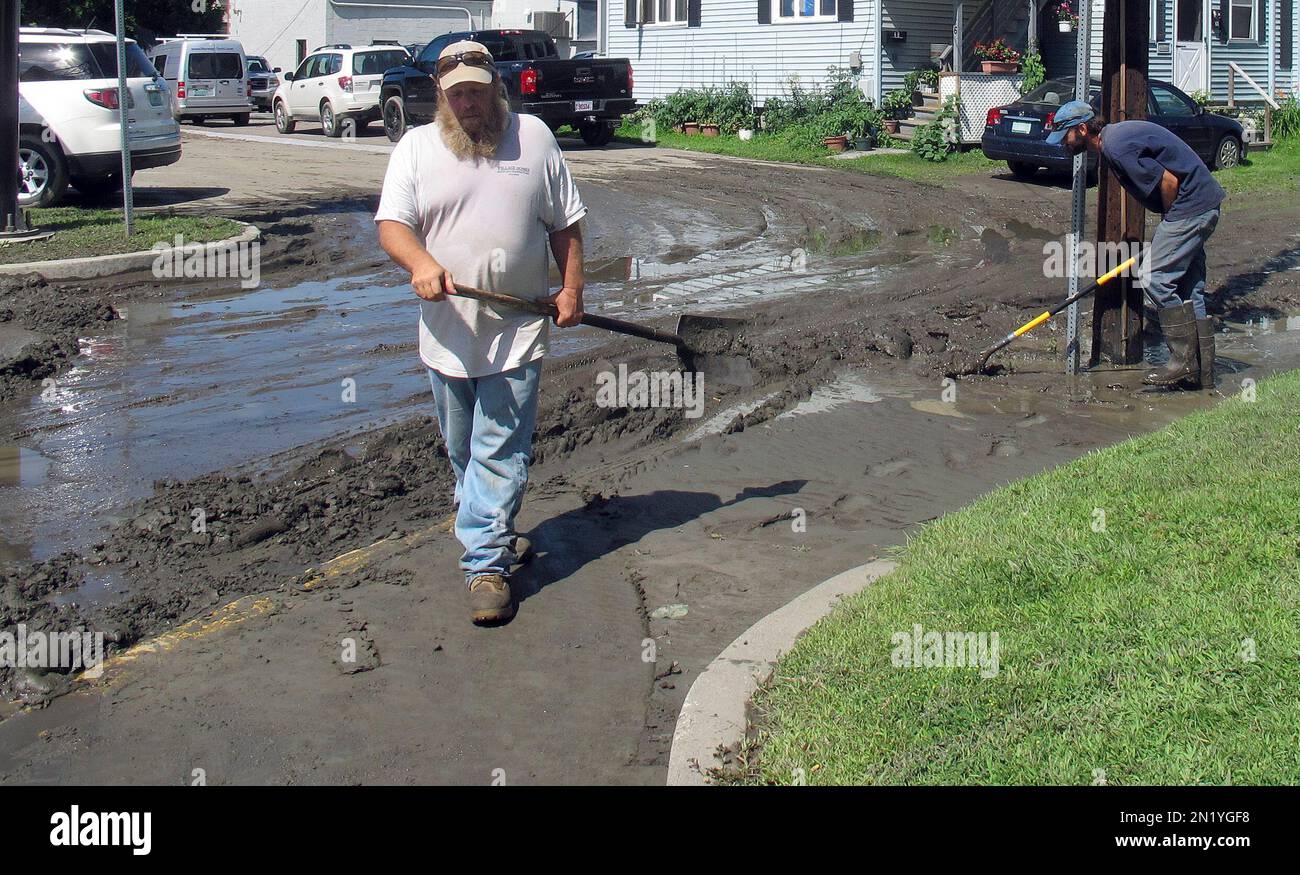 Wayne Ferno, left, and Chip Barnett clean mud from a sidewalk outside ...