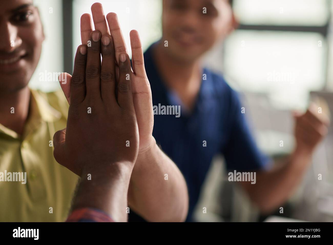 Team members giving each other high five after finishing work on big ...