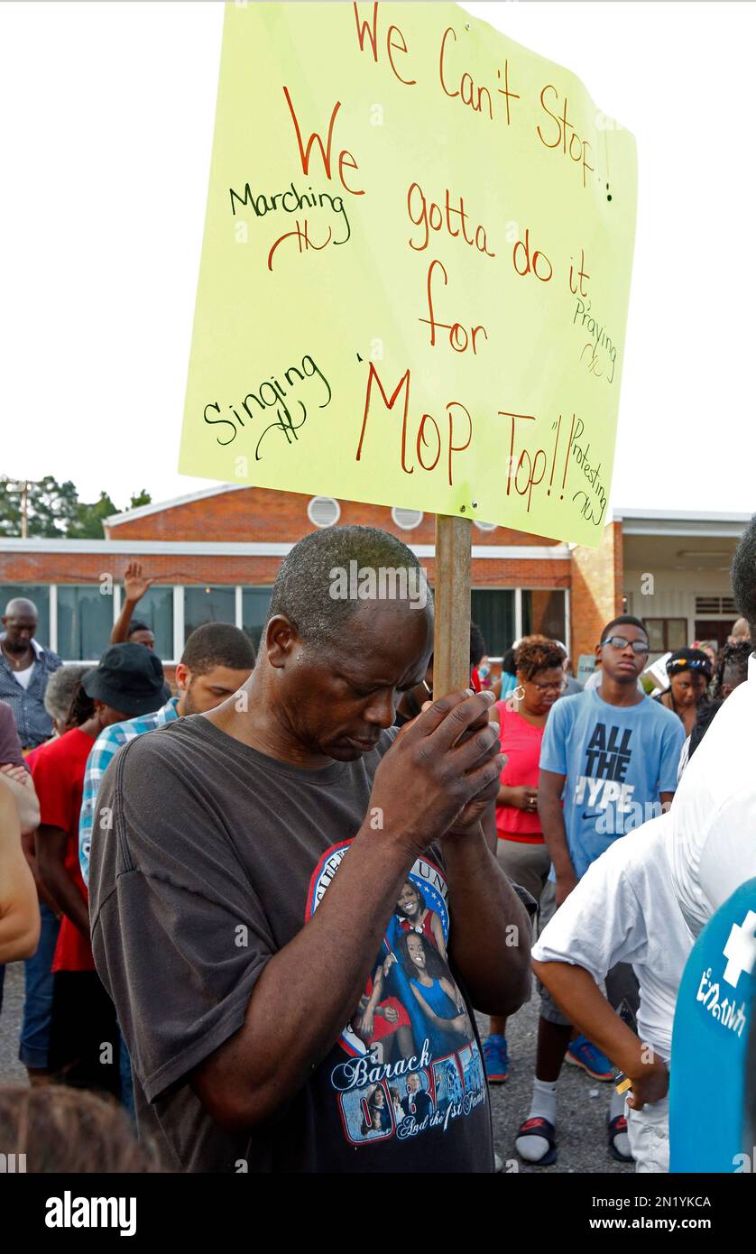 Dennis Evans bows his head in prayer during a remembrance and rally for ...