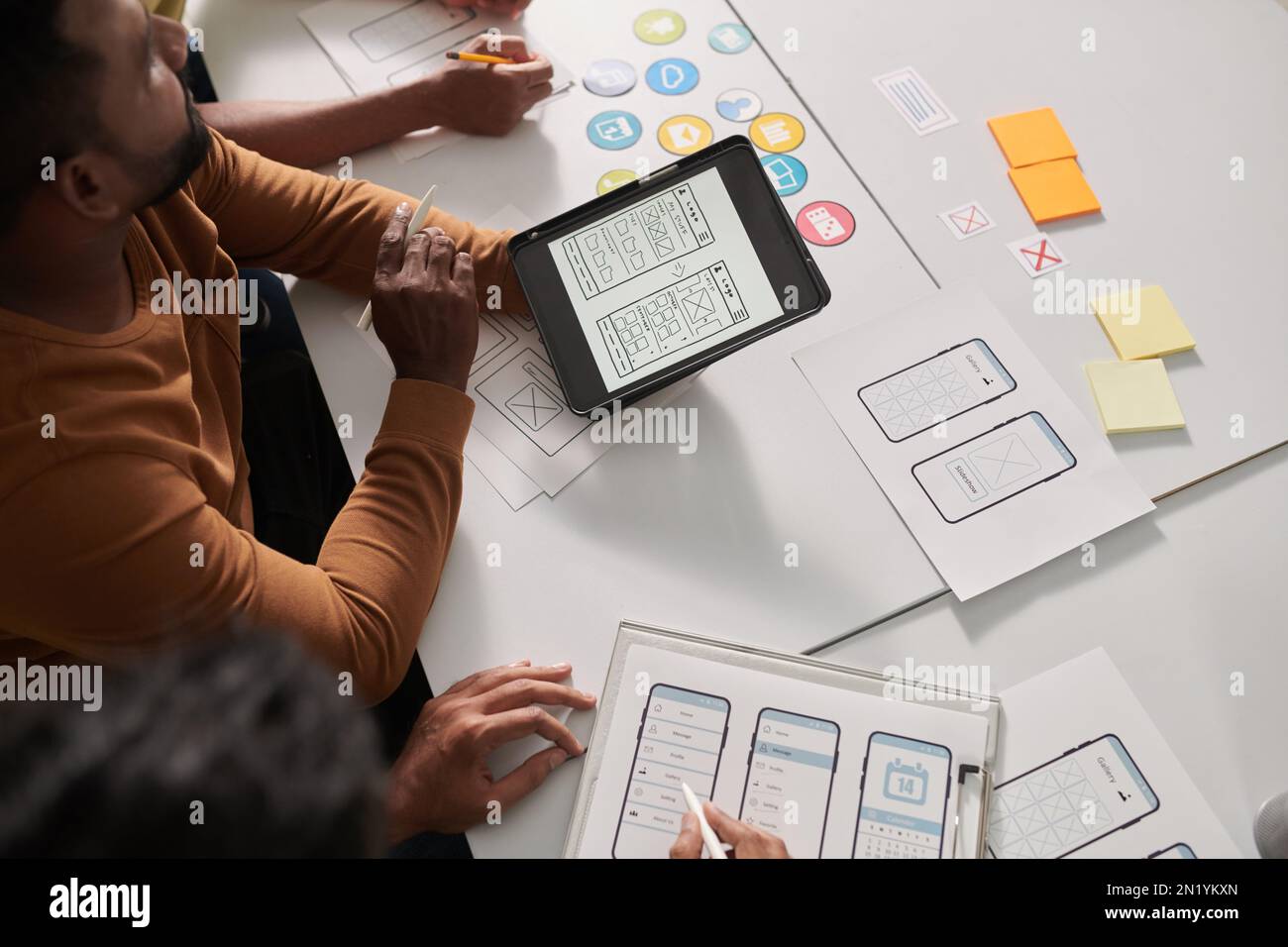 Group of UX designers discussing sketch of mobile application interface ... Group of UX designers discussing sketch of mobile application interface ...