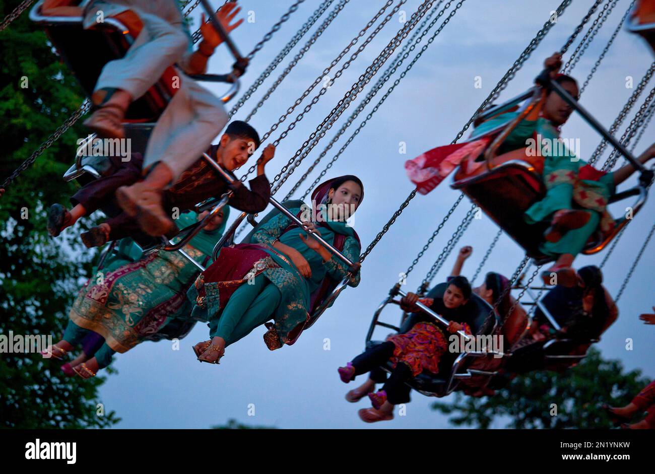 Pakistanis enjoy a ride at a carnival on the occasion of Eid al-Fitr ...