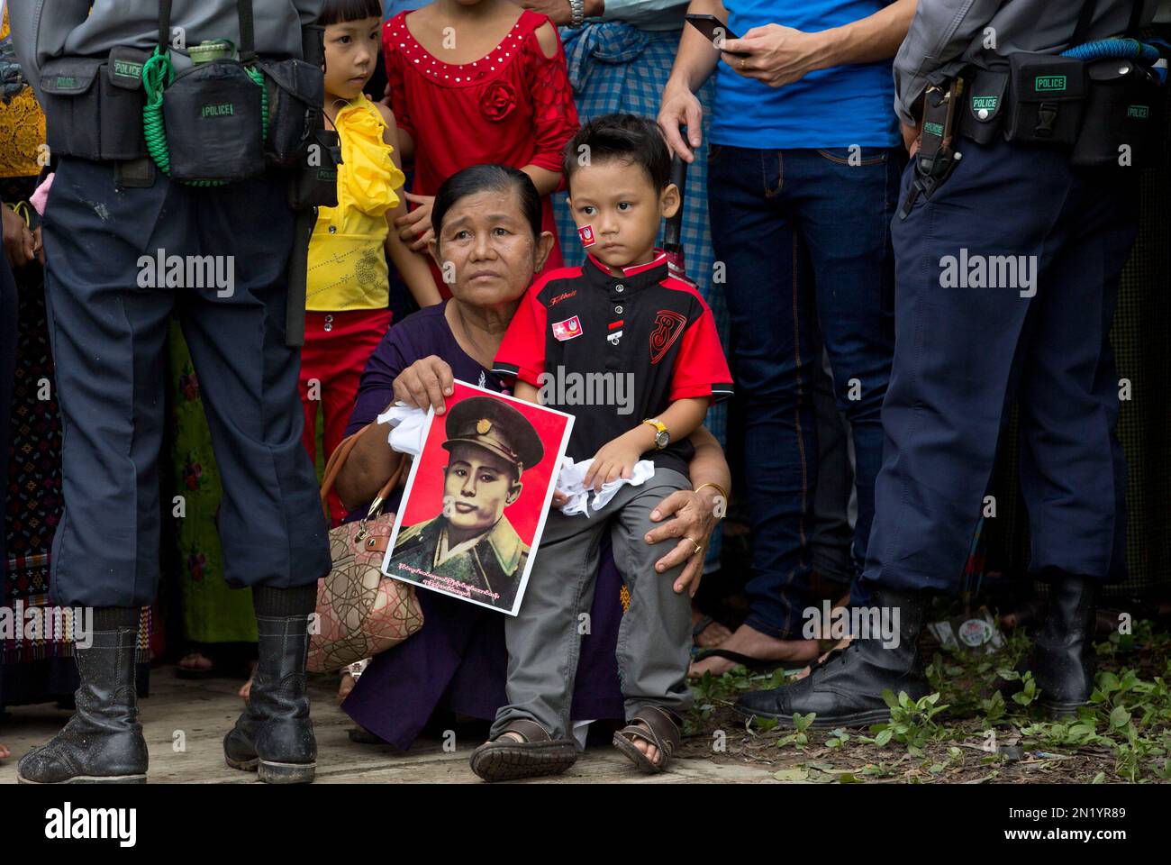 A woman holds a portrait of Gen. Aung San at a barricade leading to ...