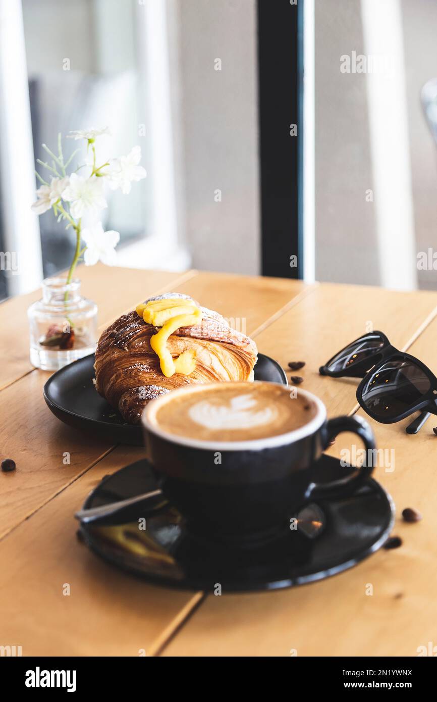 Coffee prepared by a barista in a black cup on a restaurant table. Food ...
