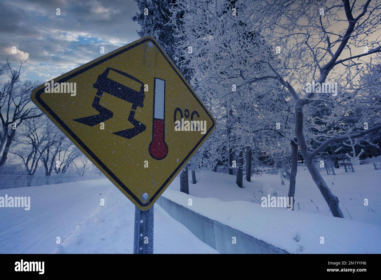 Sign indicating slippery conditions on ice covered road Stock Photo - Alamy