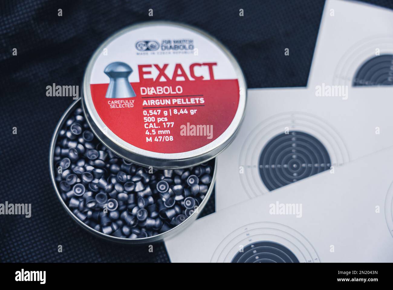 circle box full of air gun pellets next to shooting target paper. High ...