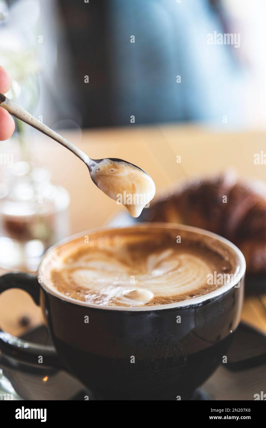 Spoon stirring coffee in a hipster coffee shop. Relaxed and classy ...