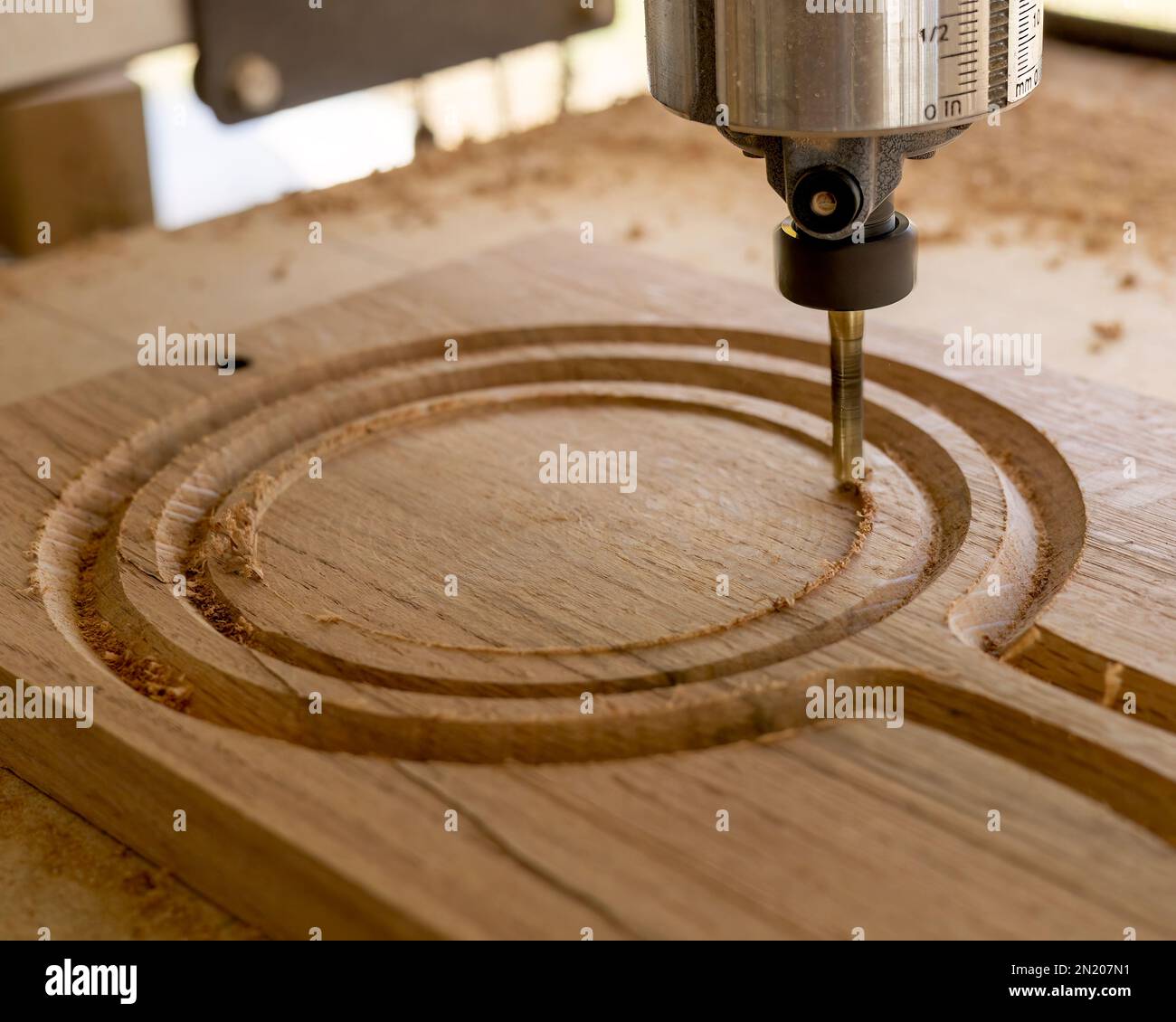 A CNC machine routing a circle on an oak wood board Stock Photo - Alamy