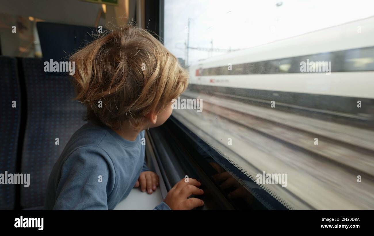 Kid travels by train going for vacation looking out window waving ...