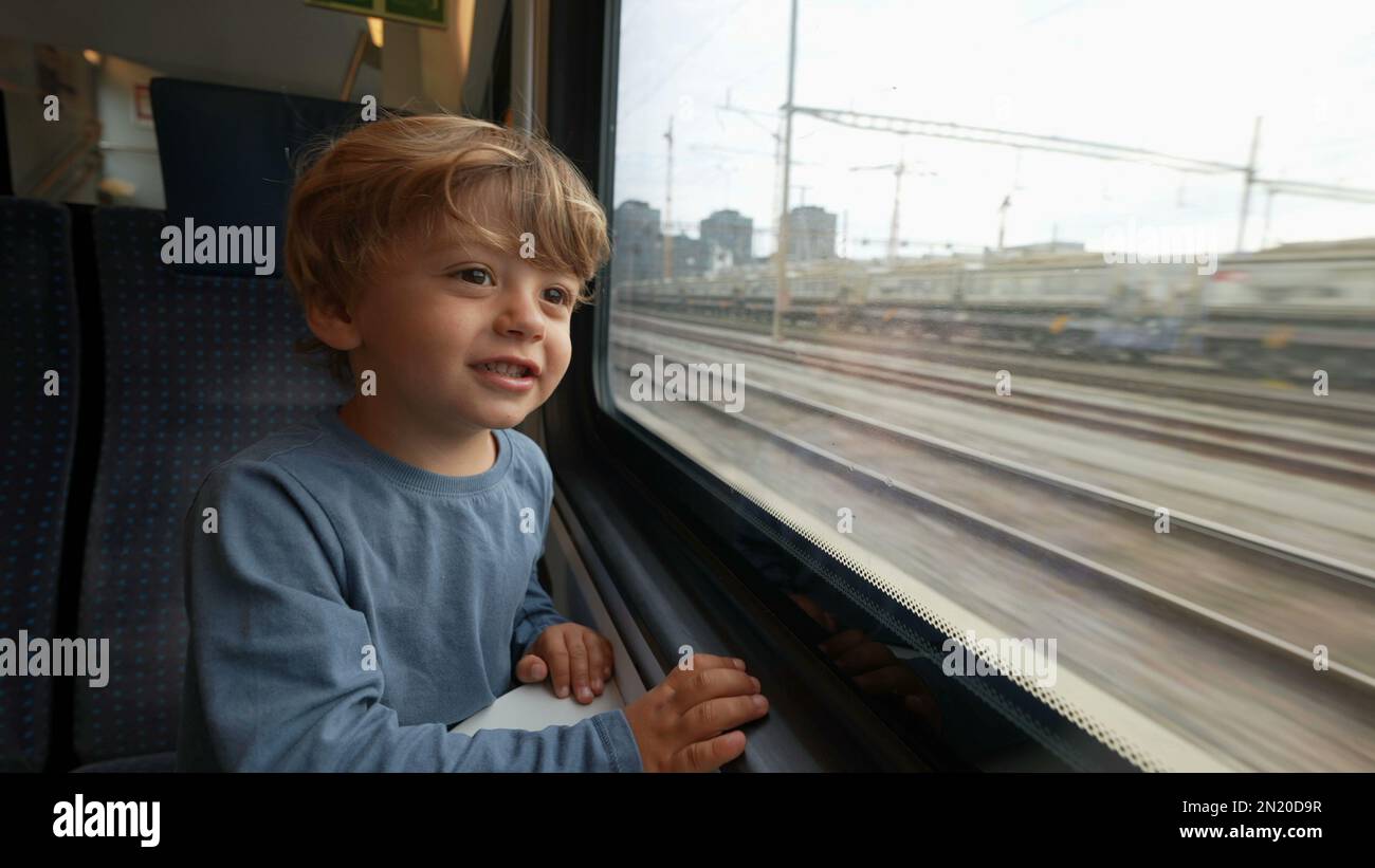 Kid travels by train going for vacation looking out window waving ...