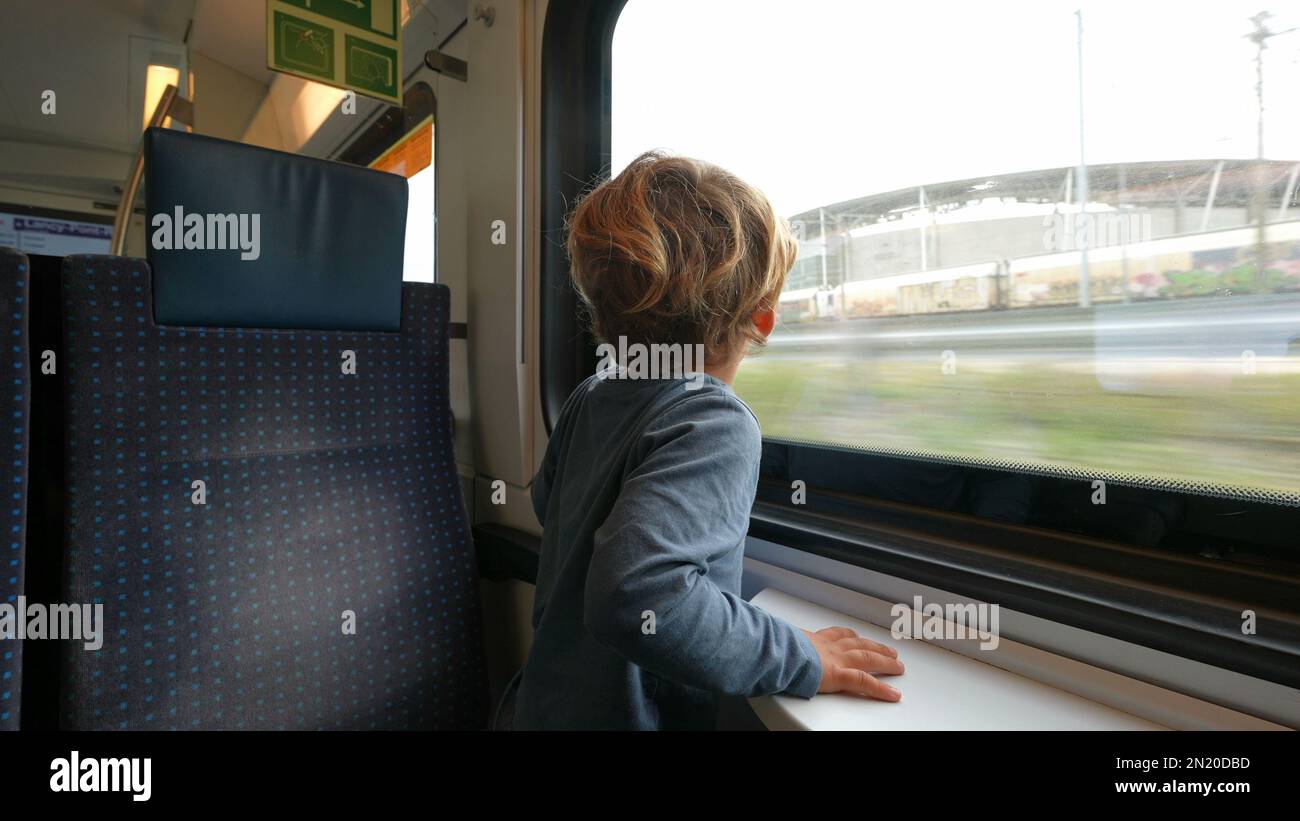 Boy looking through window while traveling train hi-res stock ...