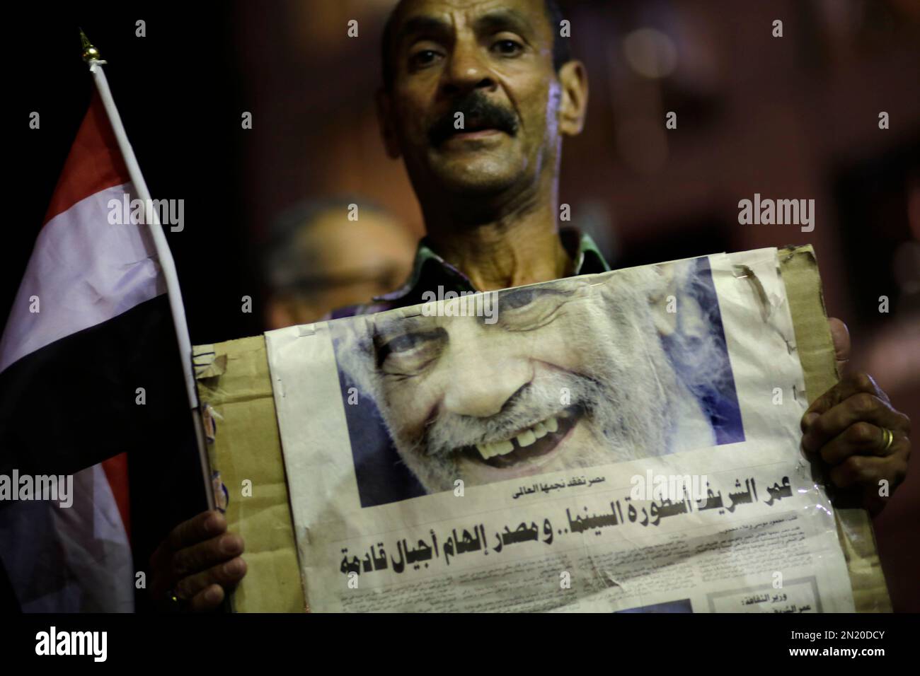 An Egyptian fan of actor Omar Sharif holds a newspaper fronted by his ...