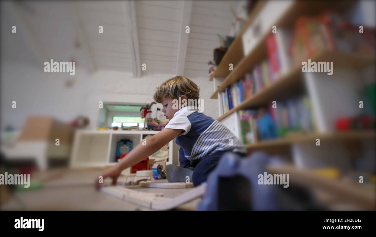 One small boy plays in his room. Candid authentic child playing in ...