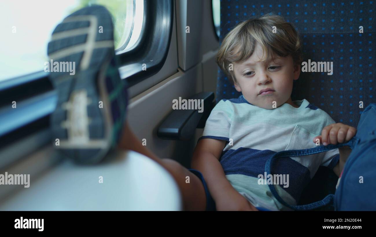 One upset child with feet on table while traveling by train ... One upset child with feet on table while traveling by train ...