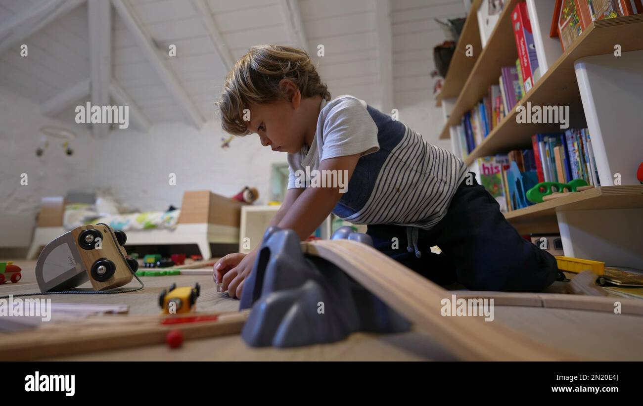 One small boy plays in his room. Candid authentic child playing in ...