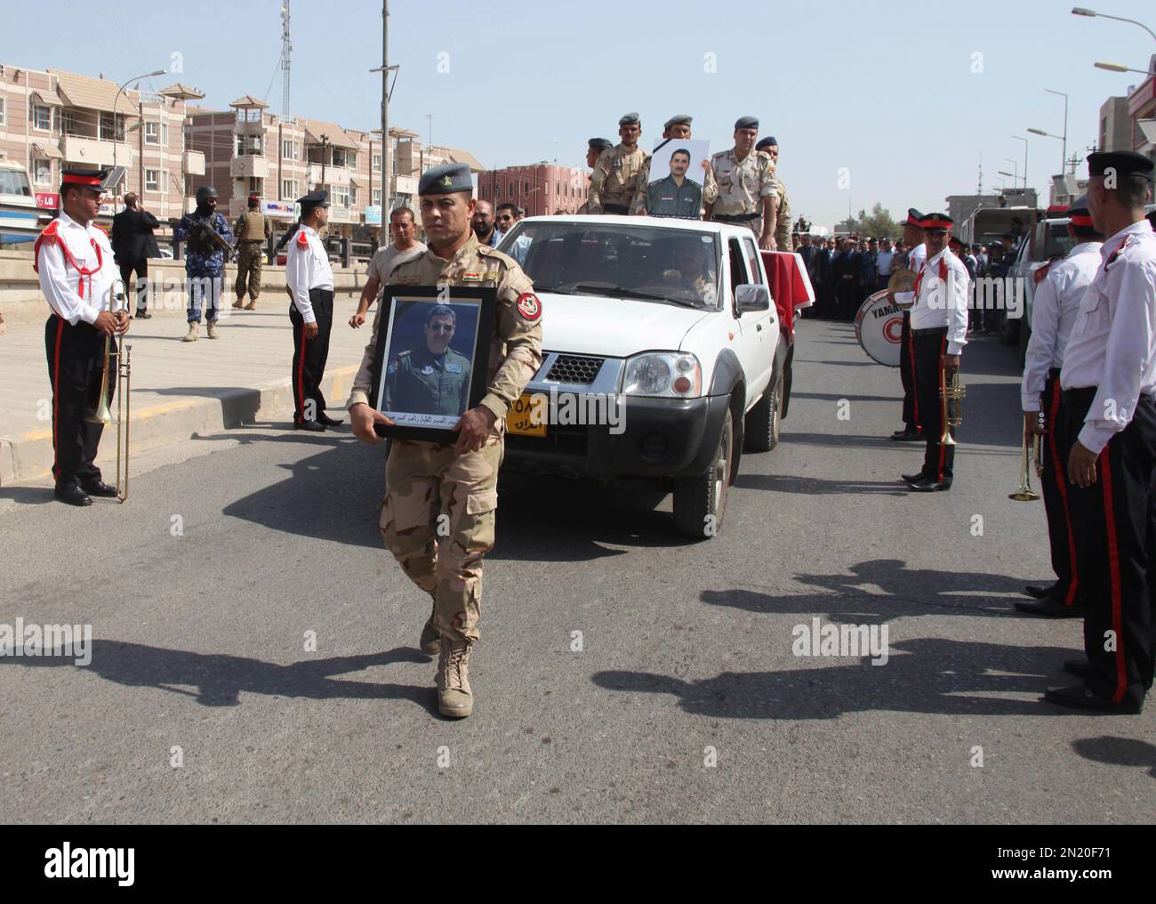 Iraqi air force officials carry the flag-draped coffin of Brigadier General Rased Mohammed ...