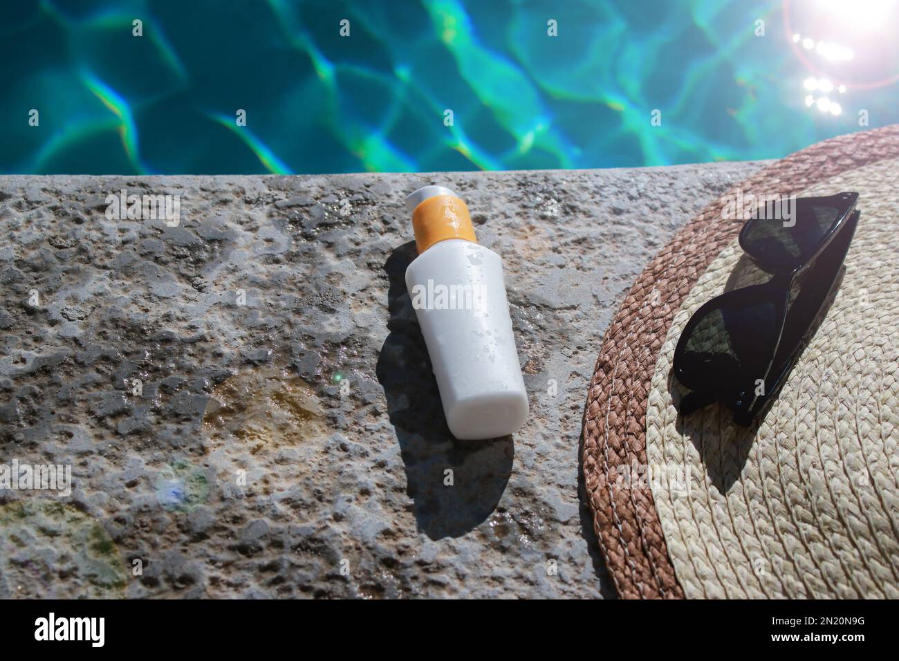 white mock up sunscreen bottle at the pool with sunglasses and summer ...
