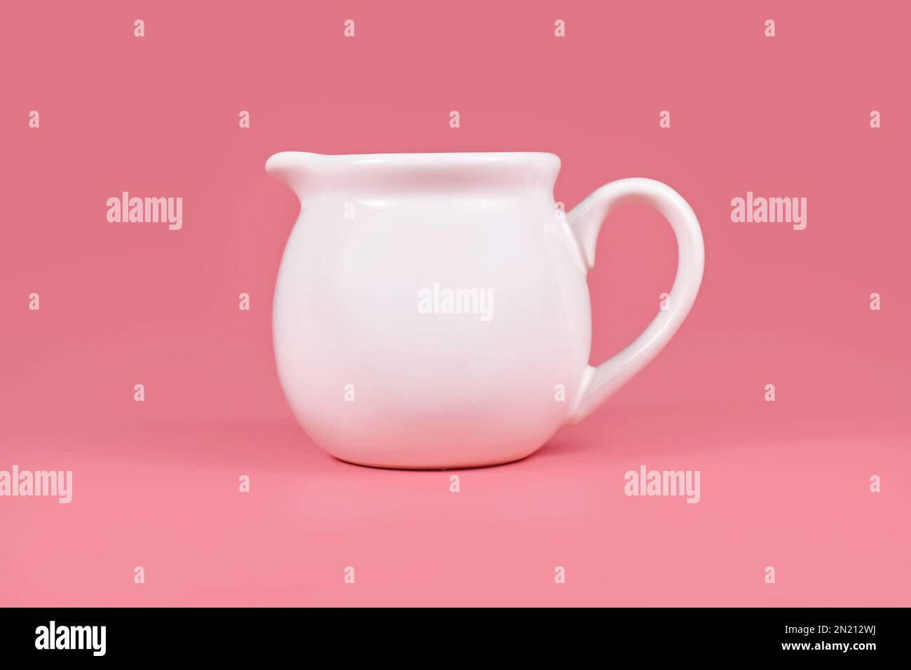 White creamer pitcher on pink background Stock Photo - Alamy