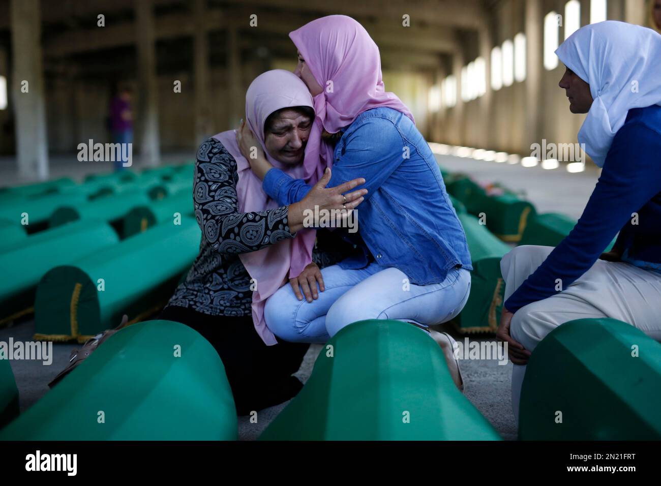 Bosnian Muslim woman Ajsa Husejnovic, left, cries with family members ...
