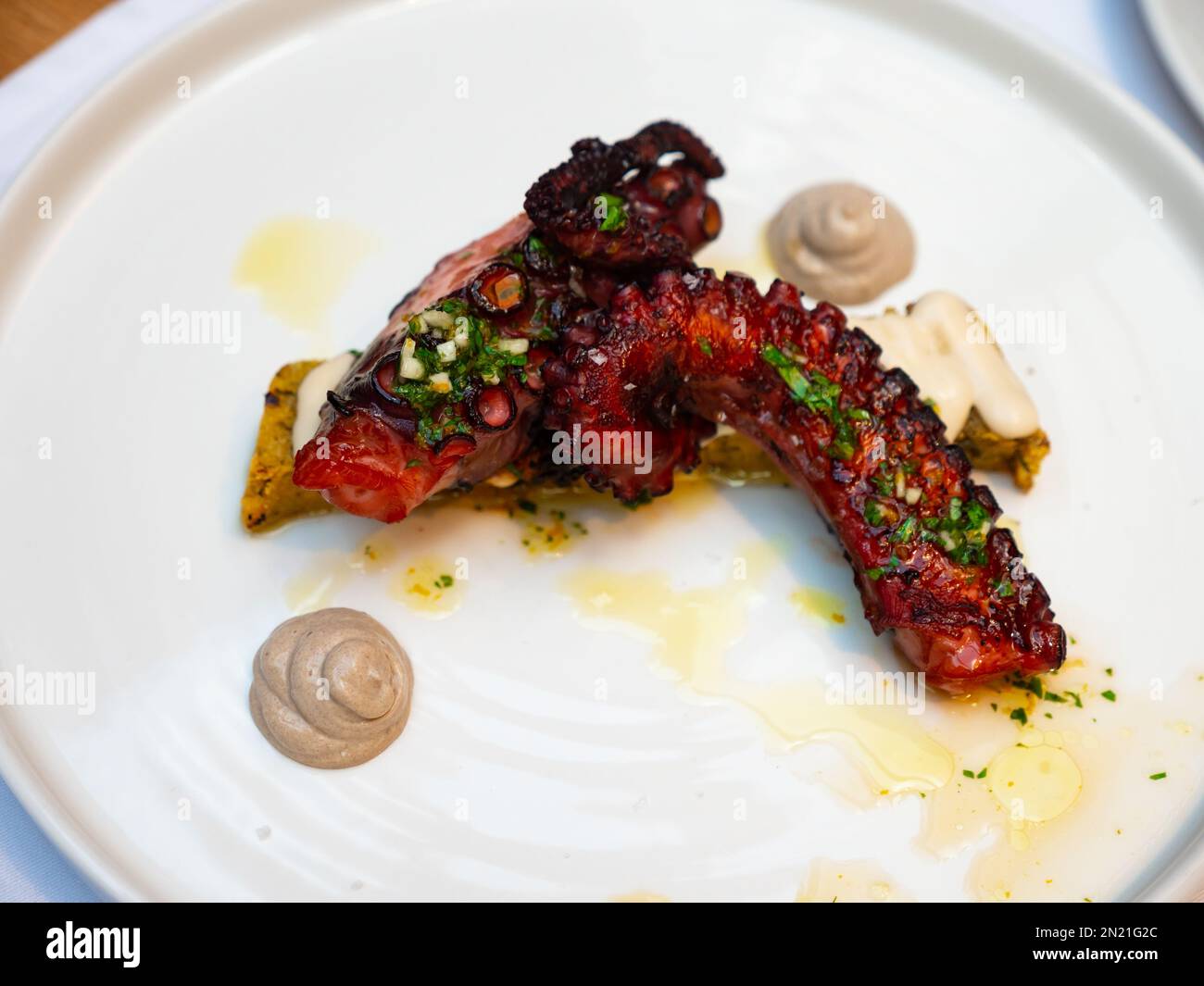 Delicious cooked octopus tentacles on plate Stock Photo - Alamy