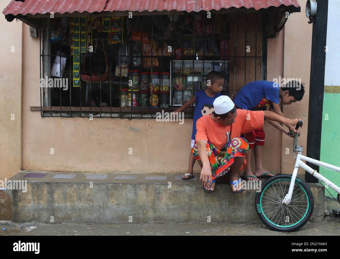 Filipino Muslim Munib Dalidig, center, holds a bicycle beside the ...