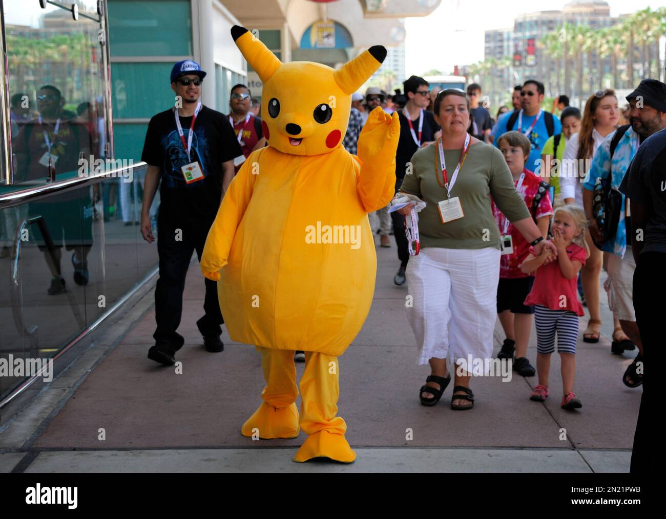 A fan dressed as Pokemon's Pikachu walks past the lines before Preview ...