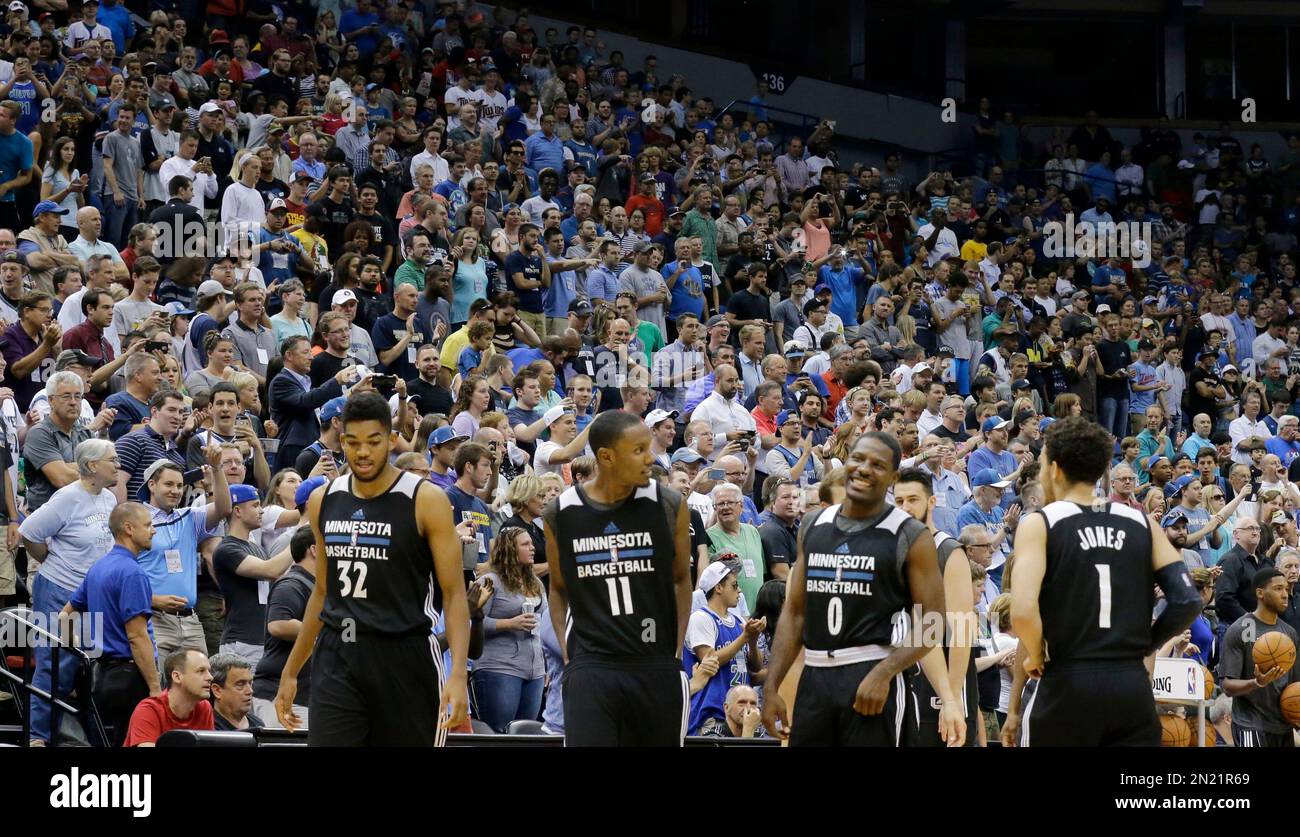 Fans cheer and take photos as the Minnesota Timberwolves take the court ...