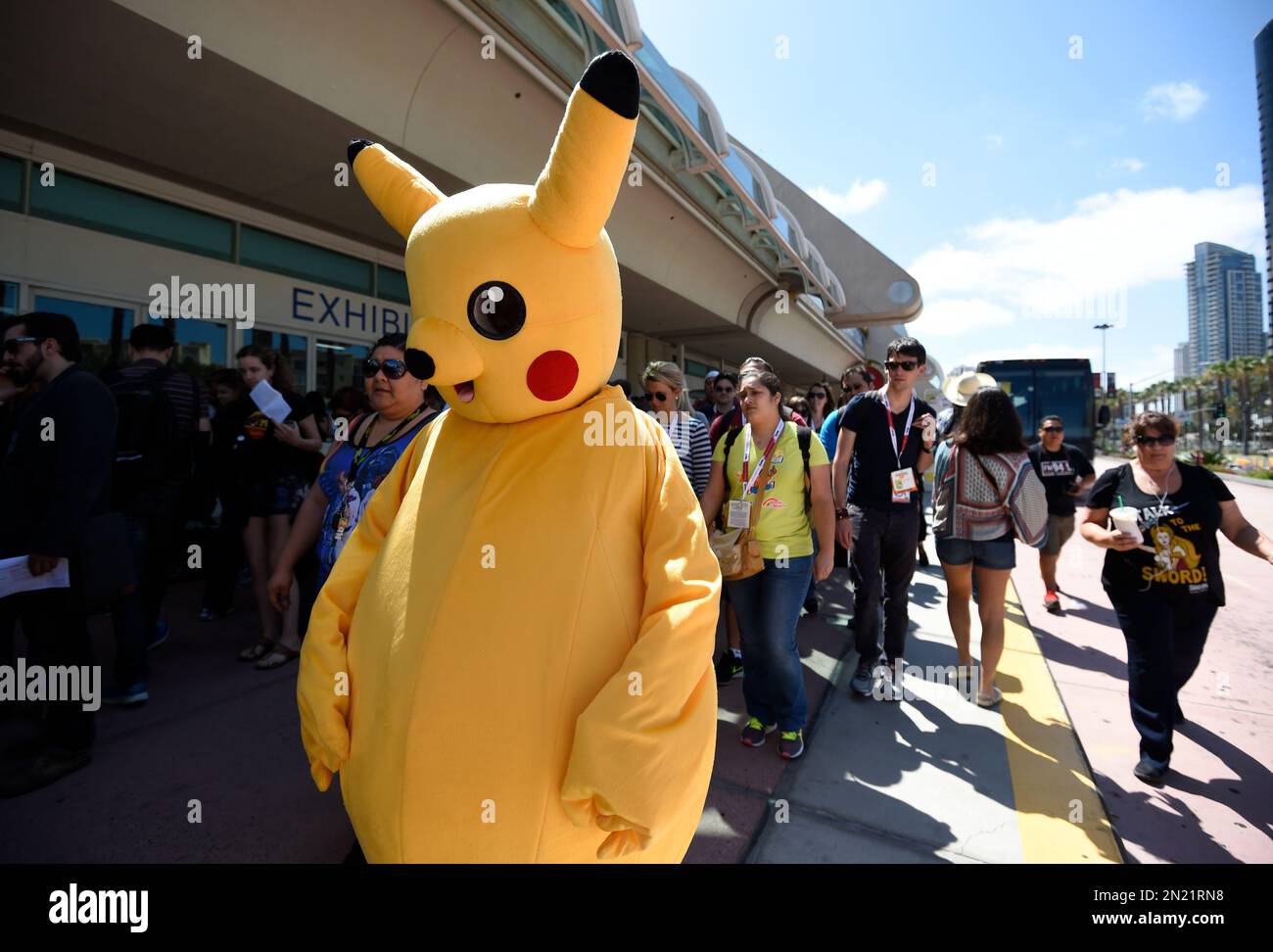 A fan dressed as Pokemon's Pikachu walks past the lines before Preview ...