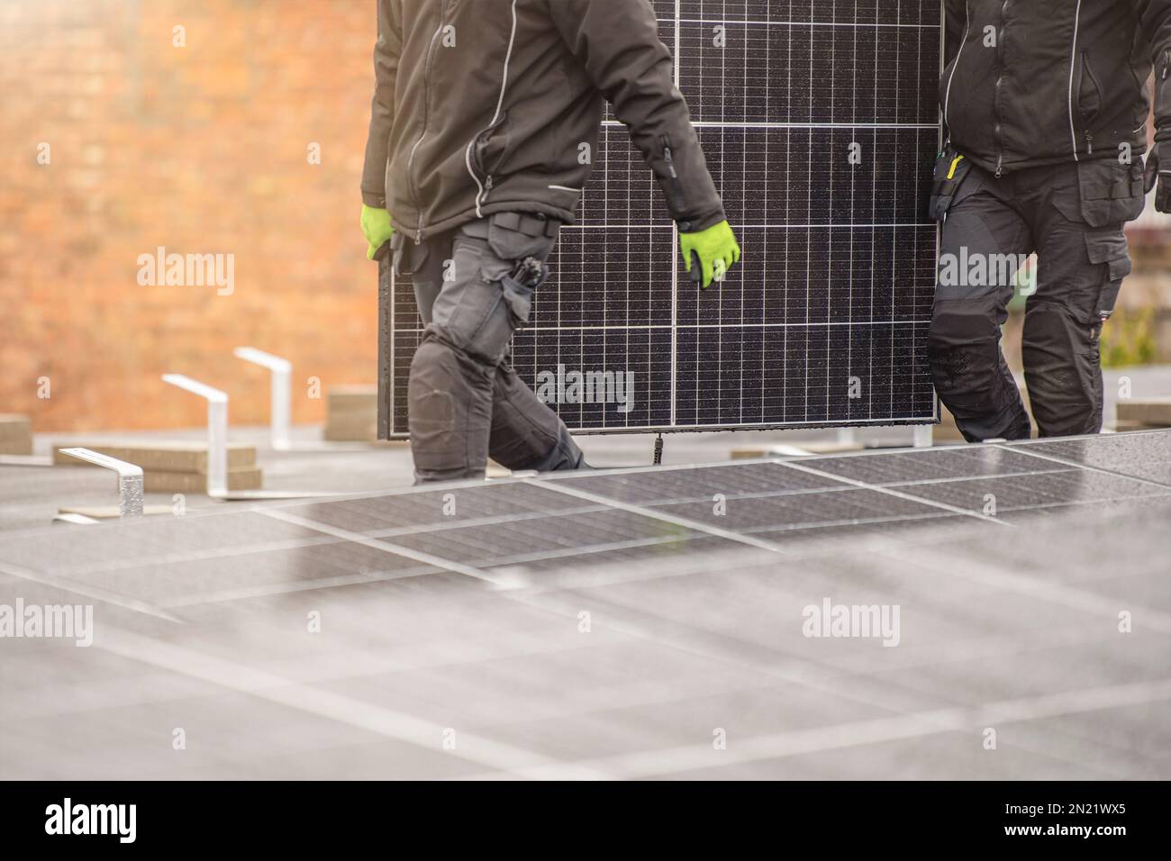 The process of installing solar panels. Solar panel installers work on the roof. Installers ...