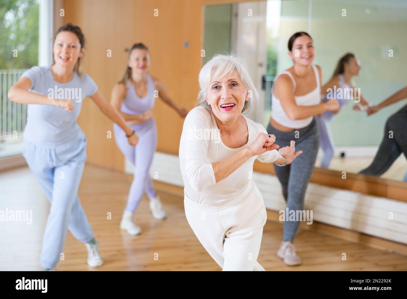 Women dancing synchronous group choreography in dance hall Stock Photo ...