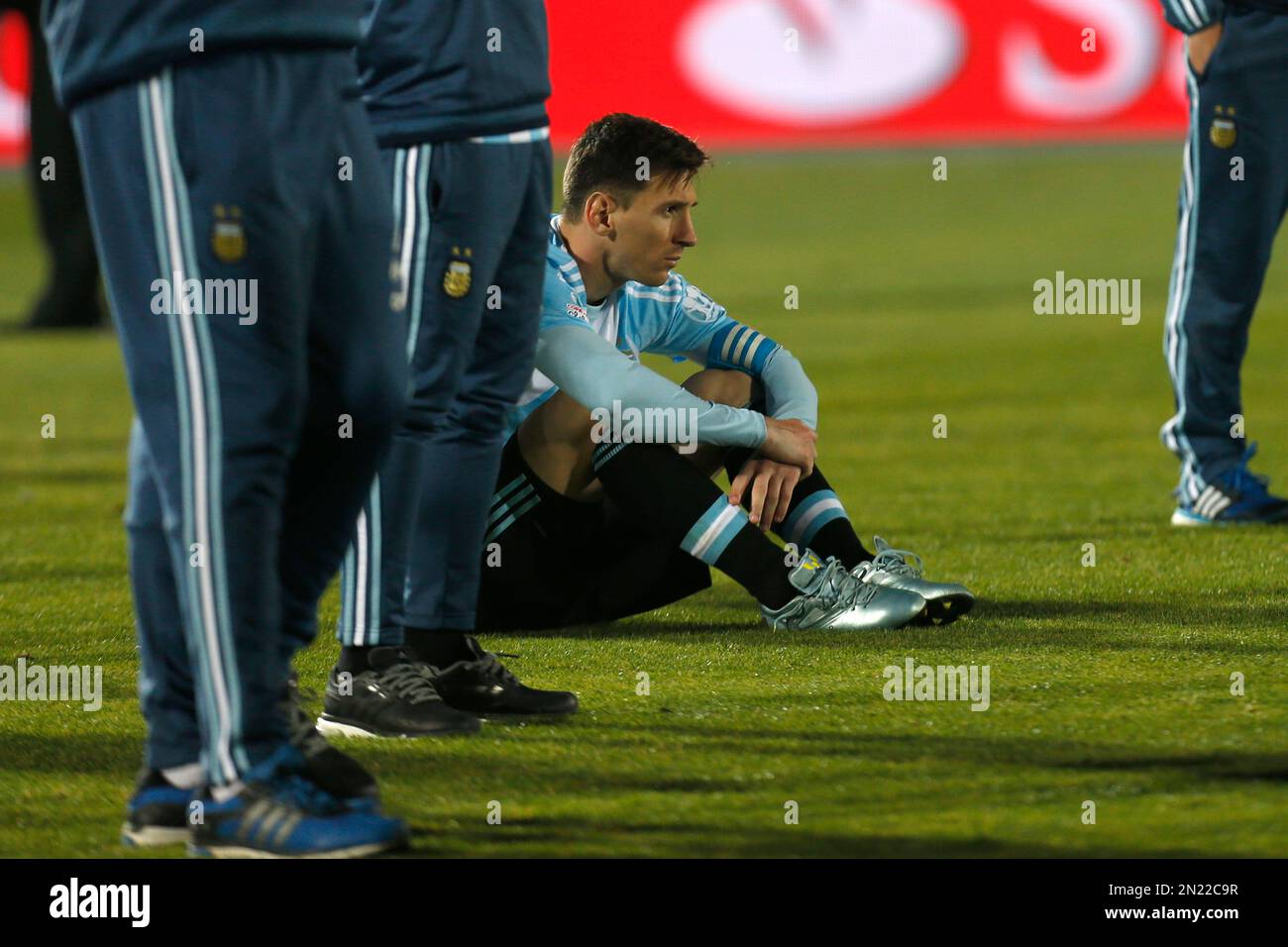 Argentina's Lionel Messi sits on the ground next to teammates during ...