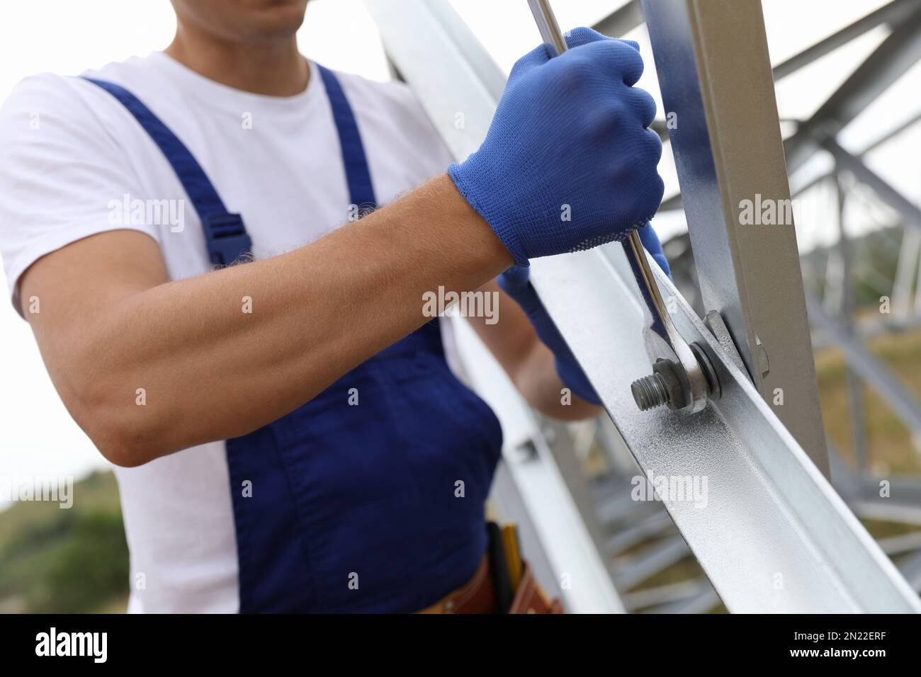 Worker building high voltage tower construction outdoors, closeup ...