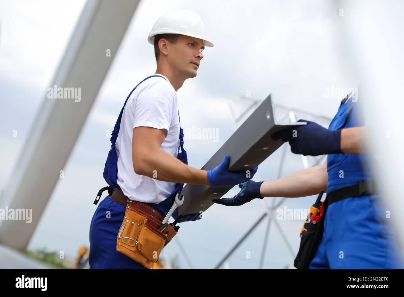 Workers building high voltage tower construction outdoors. Installation ...