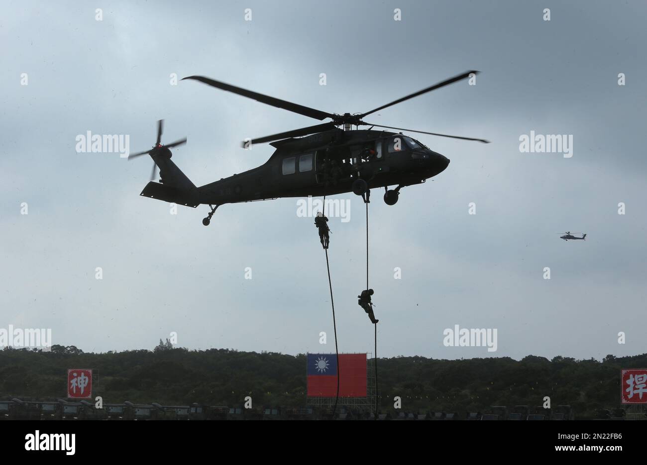 Taiwan's military rappel from a UH-60M Blackhawk helicopter in front of ...