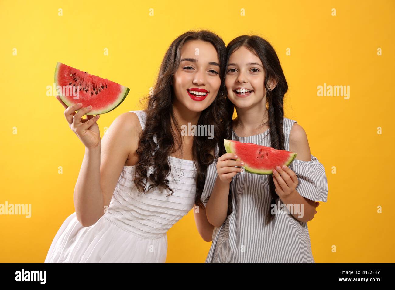 Happy girls with watermelon on yellow background Stock Photo - Alamy