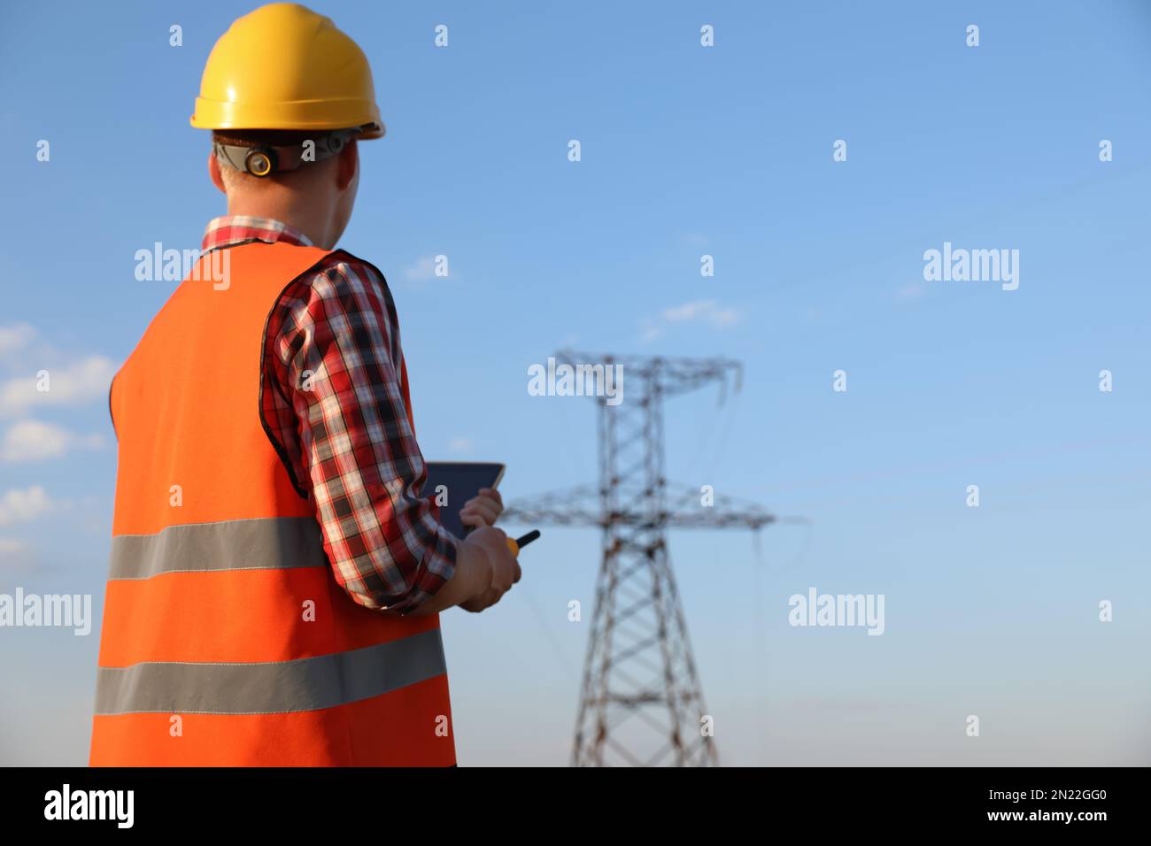 Electrical engineer with walkie talkie near high voltage tower Stock ...
