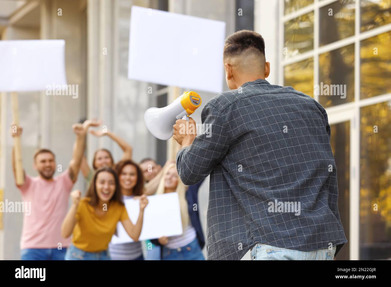 Protest leader with megaphone talking to crowd outdoors Stock Photo - Alamy
