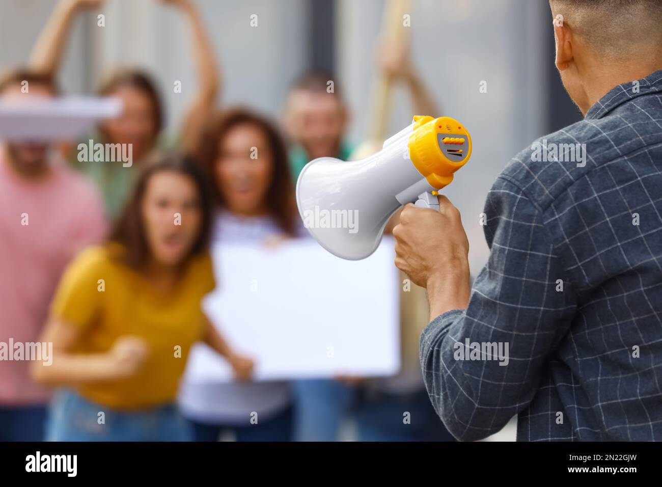 Protest leader with megaphone talking to crowd outdoors Stock Photo - Alamy