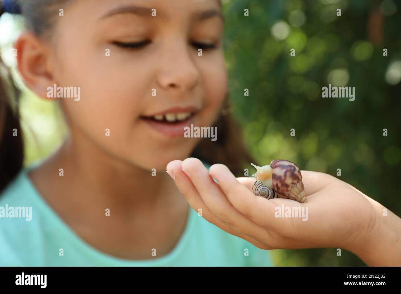 Kids playing with cute snails outdoors, focus on hand. Children ...