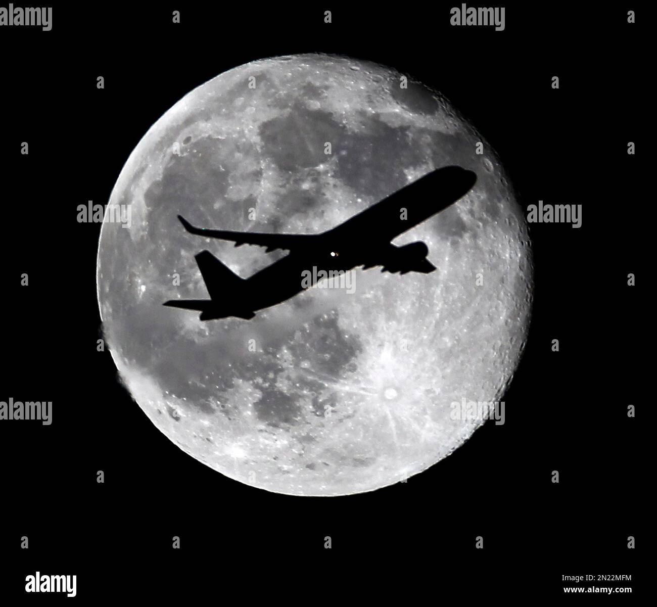 A United Airlines passenger plane crosses the waning gibbous moon, one ...