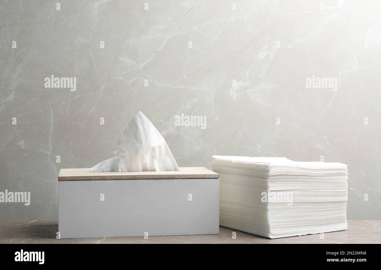 Box with tissues and stack of napkins on table Stock Photo - Alamy