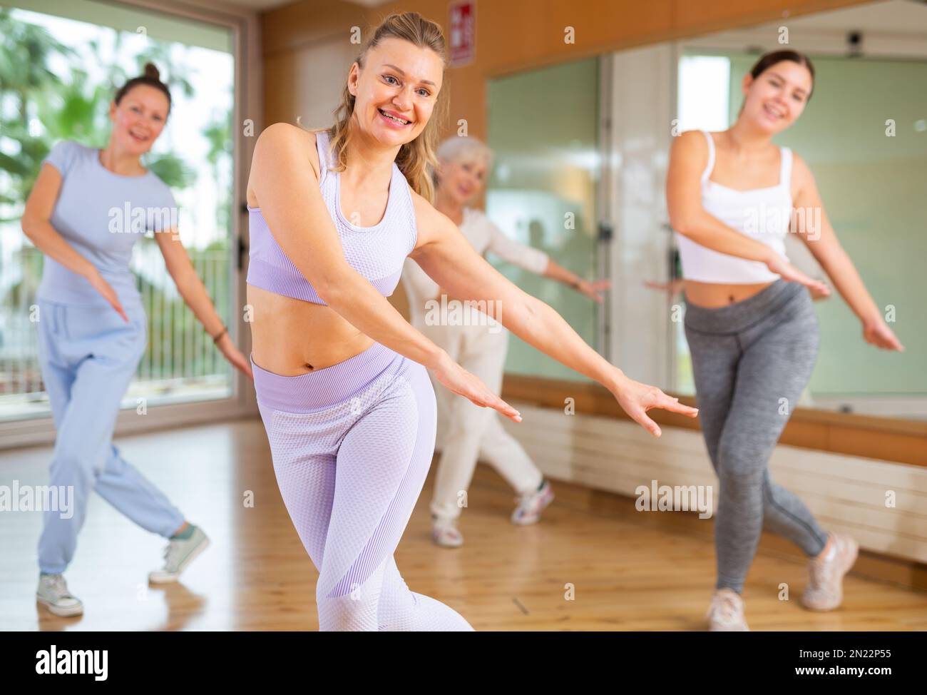 Excited positive women of different ages performing modern dancing ...
