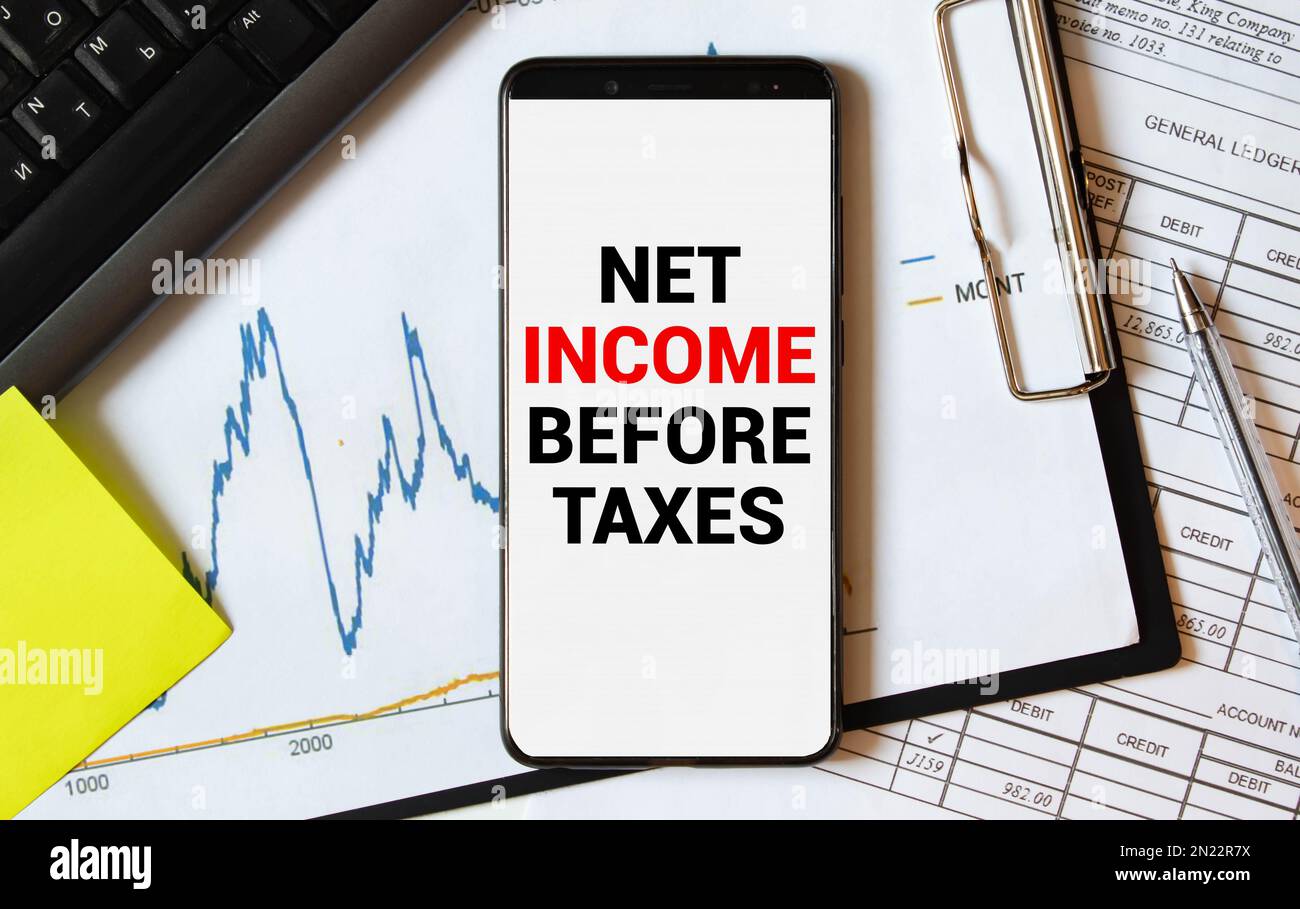 Net Income Before Taxes, text on white paper on torn paper background ...