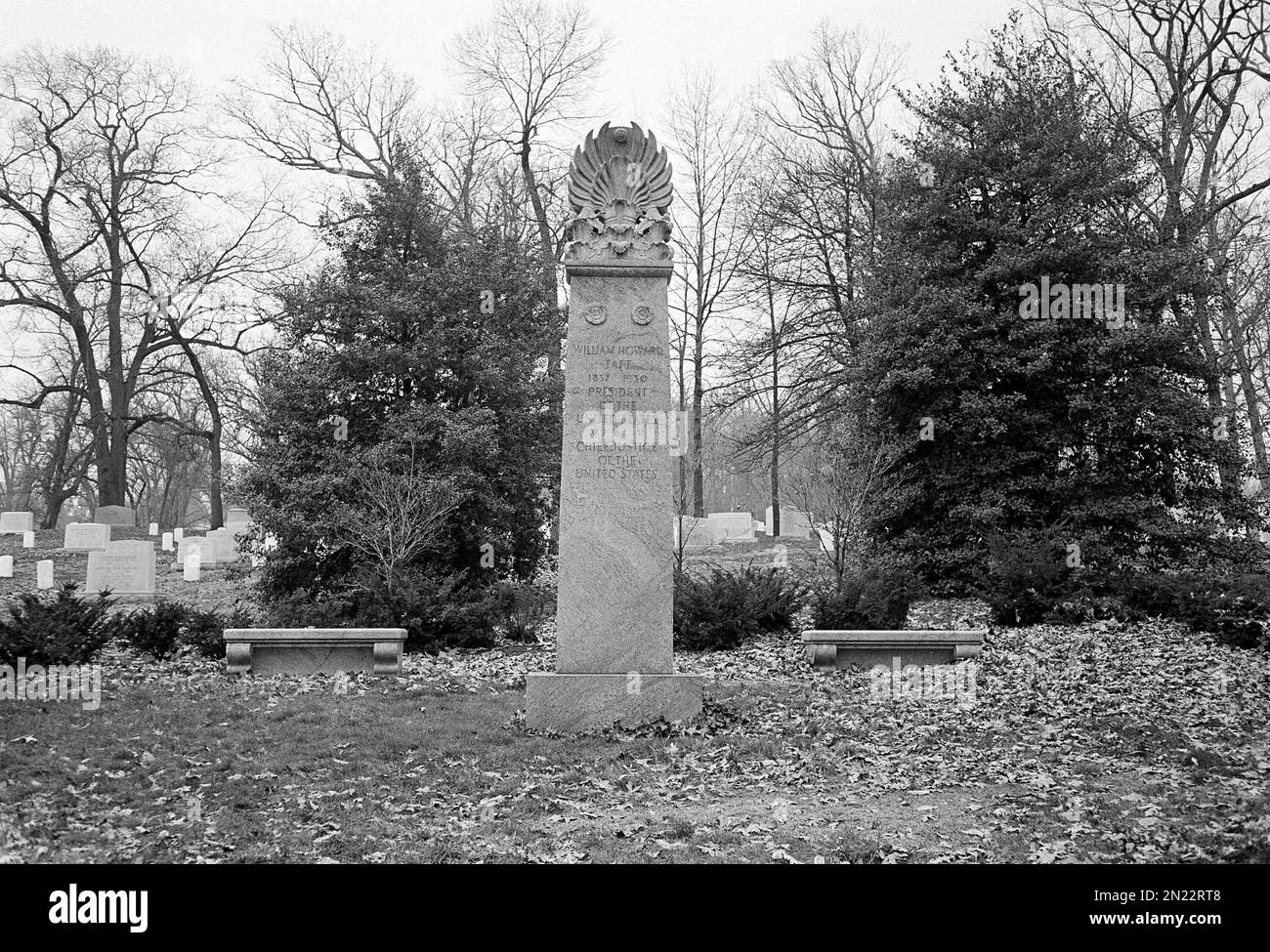 Two stone benches flank the monument marking the grave in Arlington ...