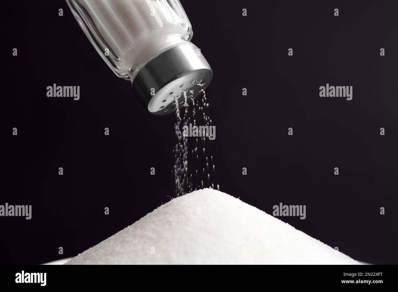Pouring salt from shaker on black background, closeup Stock Photo - Alamy