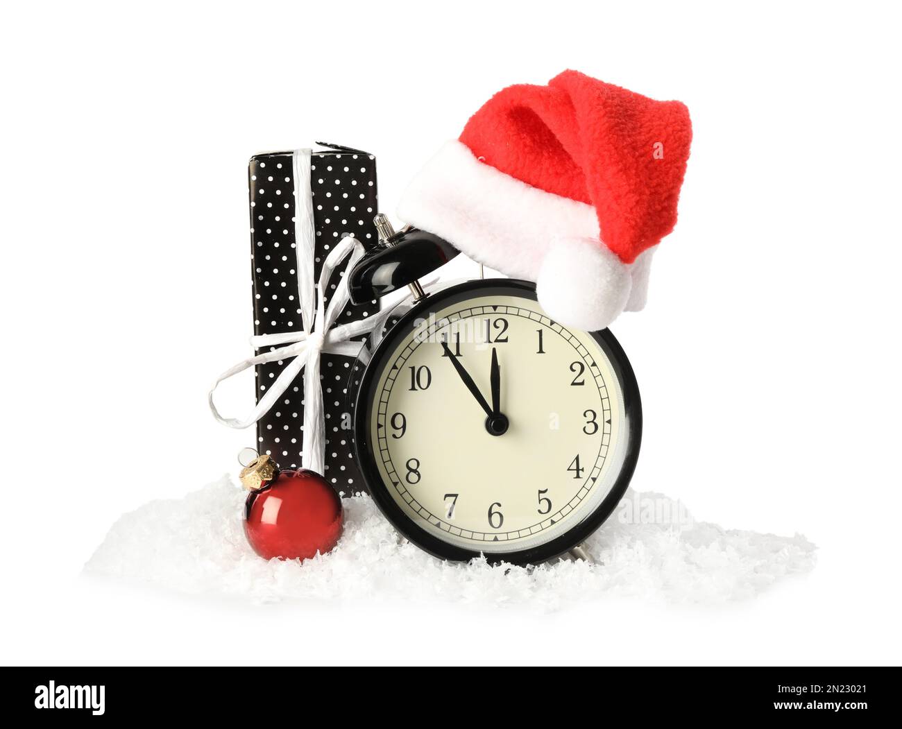 Alarm clock with Santa hat, gift and Christmas ball in pile of snow on ...