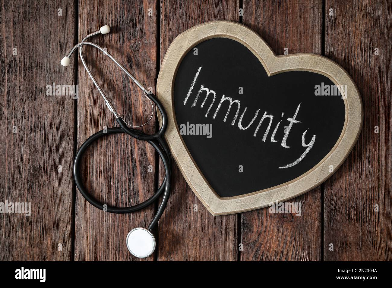 Heart shaped chalkboard with word Immunity and stethoscope on wooden ...