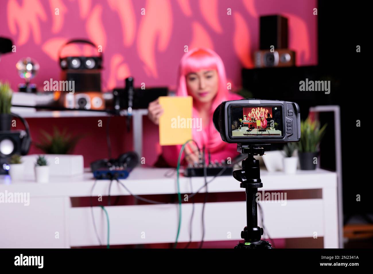 Smiling vlogger holding notebook showing product in front of camera ...