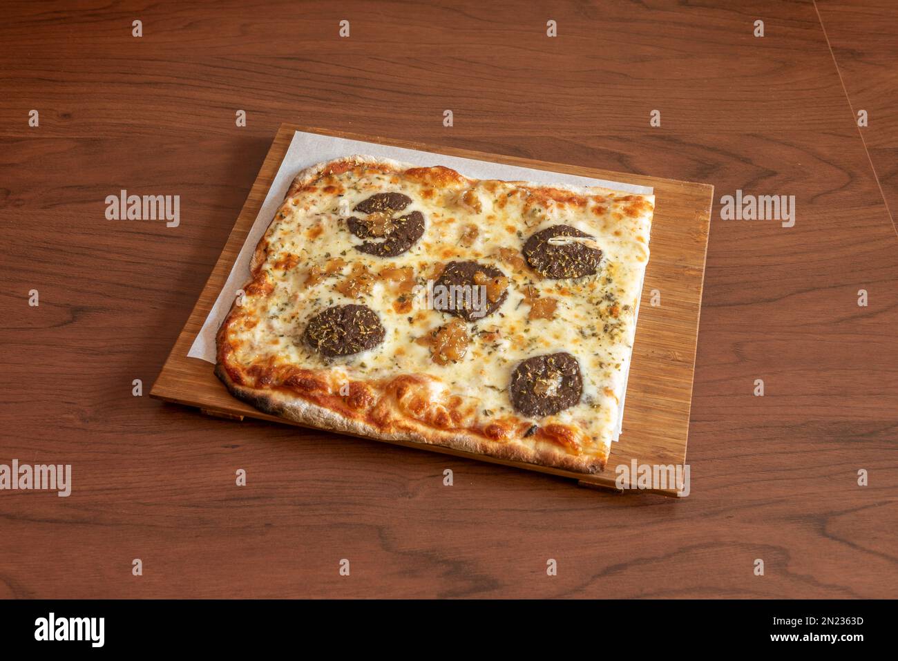 One half of a rectangular pizza with slices of blood sausage ...