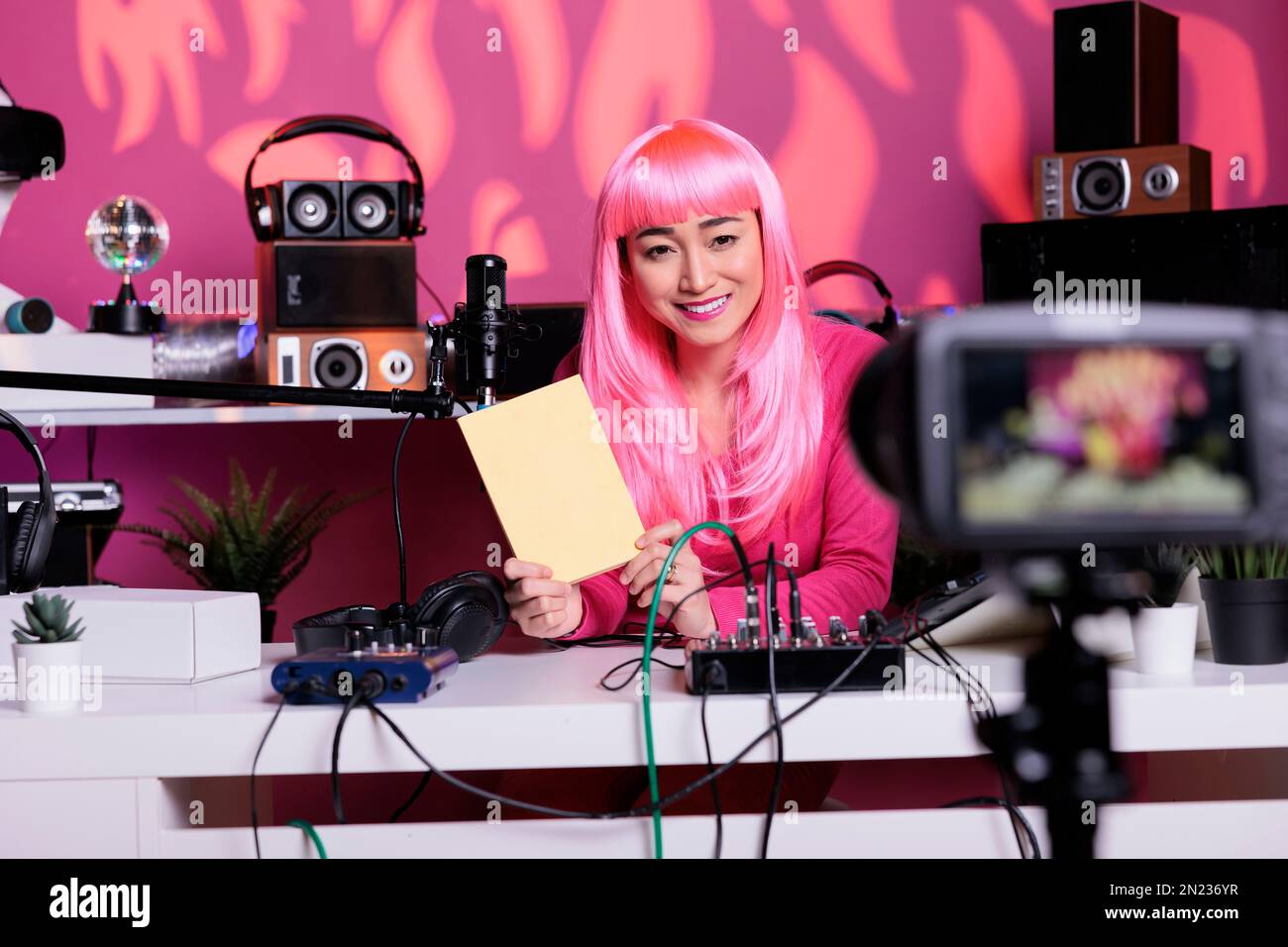 Smiling asian vlogger holding notebook presenting school supplies in ...