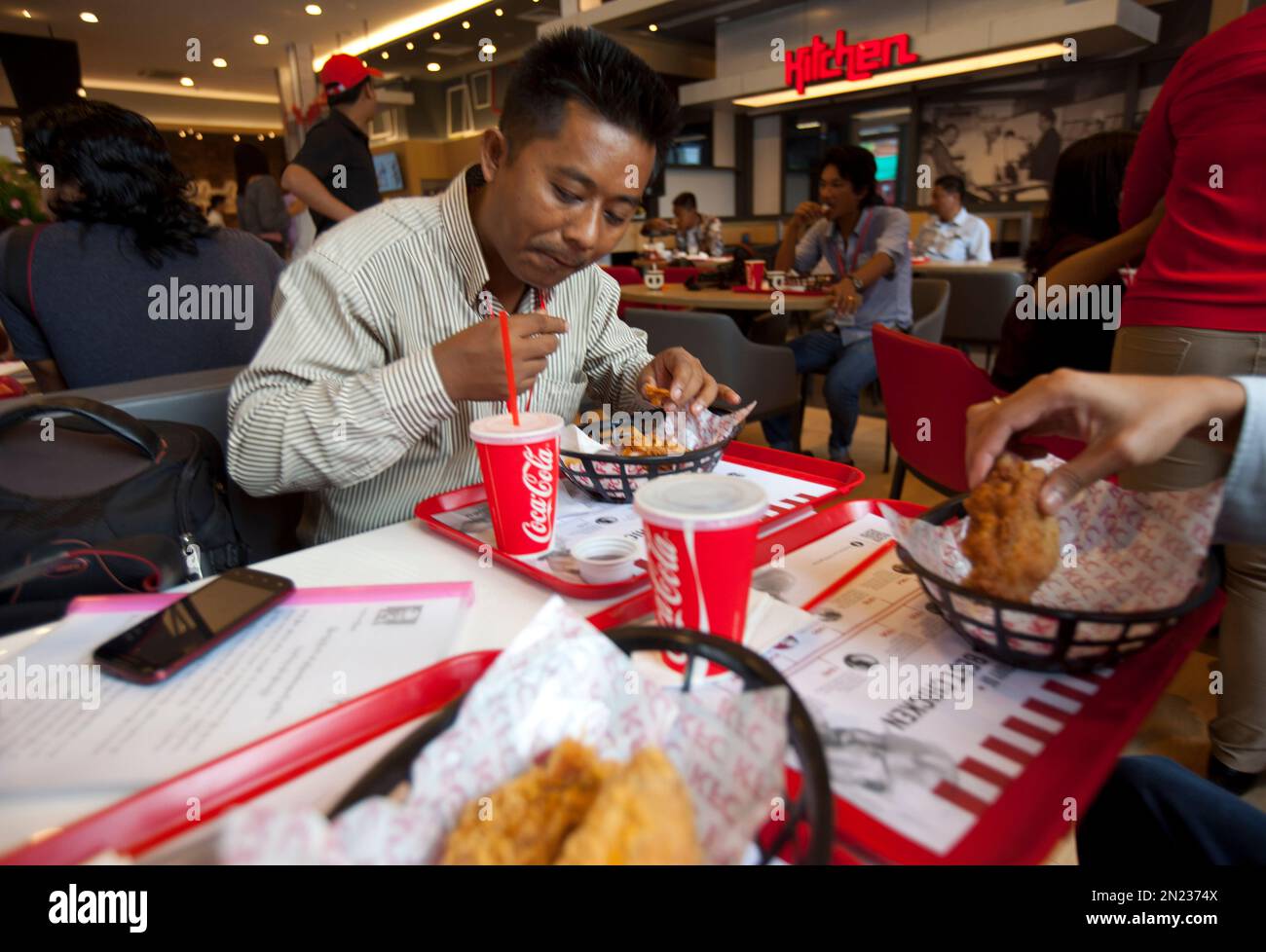 A customer eats at a newly opened KFC fried chicken restaurant Tuesday, June 30, 2015, in Yangon ...